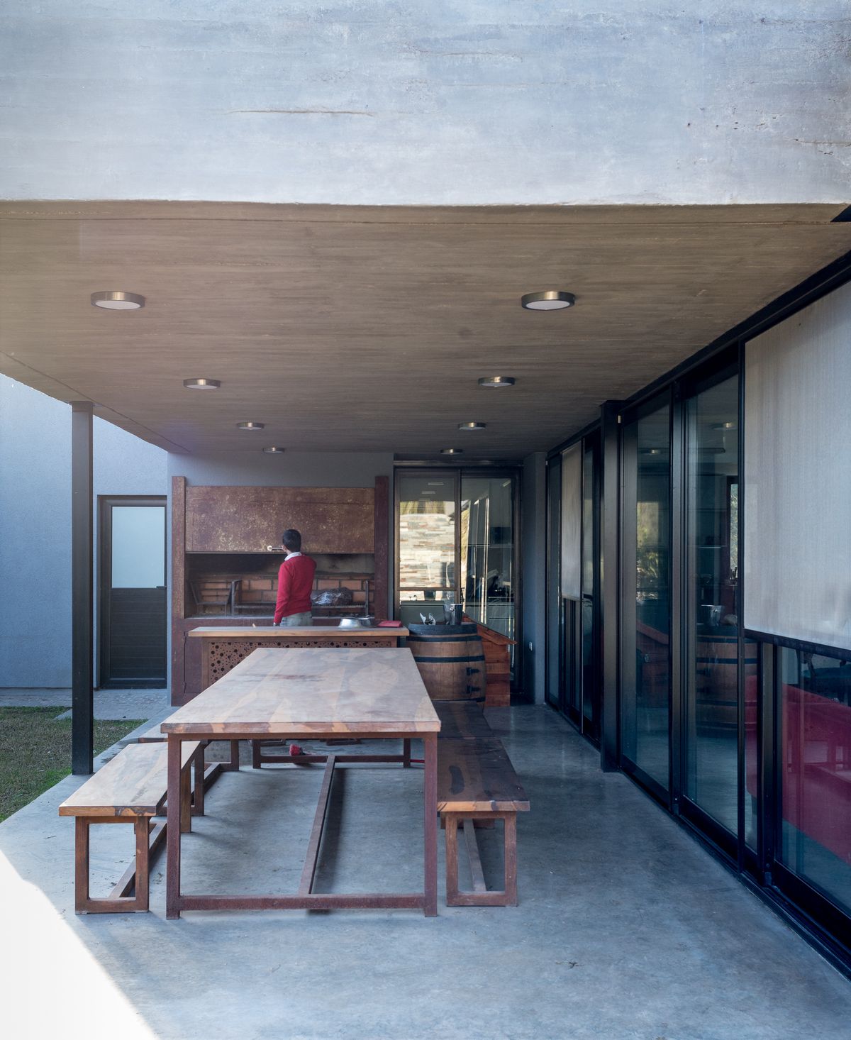 Un patio verde triangular es epicentro organizativo de una casa